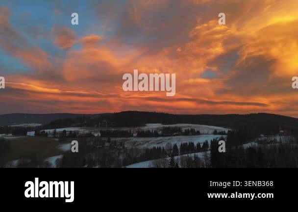 An aerial perspective shows snow-covered hills and dark coniferous ...
