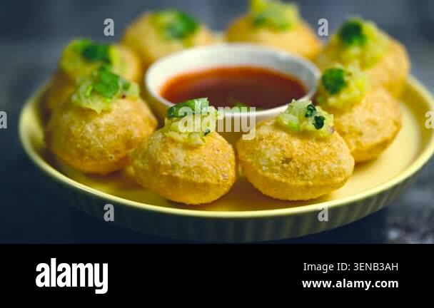 Close up of Indian street food fuchka on a plate glass with sour spicy ...