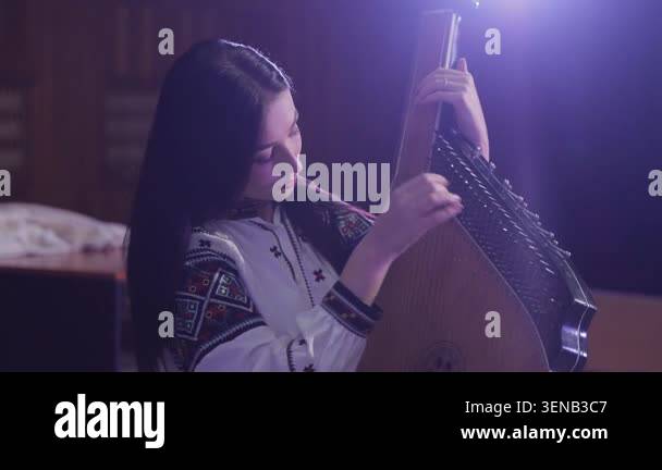 Young woman in traditional ukrainian embroidered clothing playing a ...
