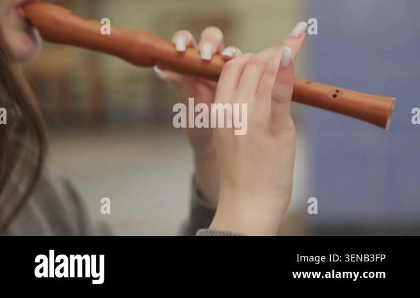Close-up of a musicians hands with a white manicure playing a wooden ...