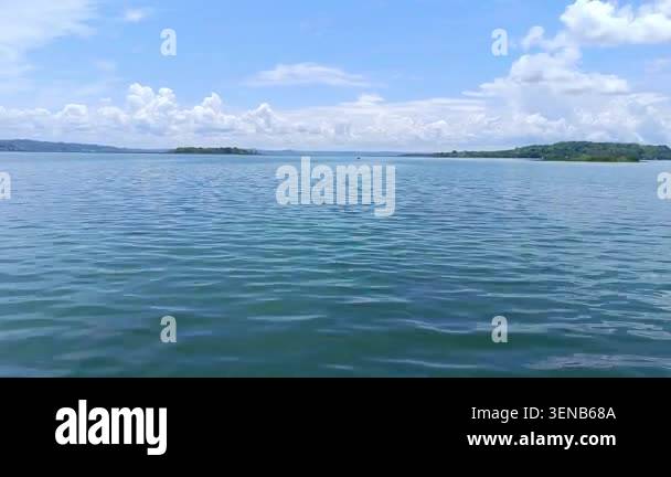 A wide scenic view of the tranquil blue water surface of Lake Peten ...