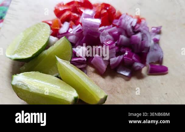 Diced fresh red onions, tomatoes, and green lime quarters prepared on a ...