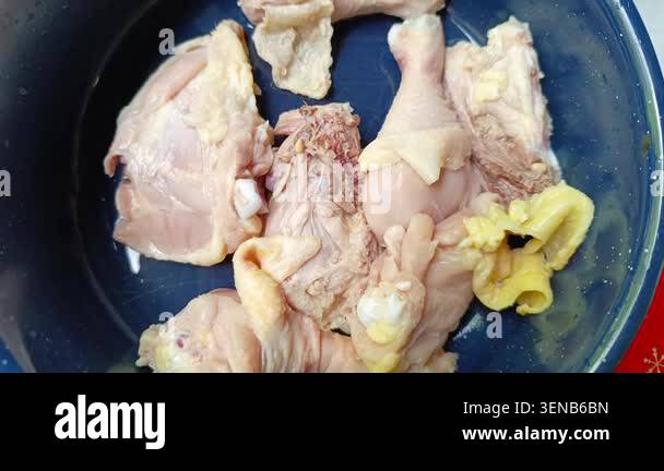 Fresh pieces of raw chicken meat with skin and bones placed inside a ...