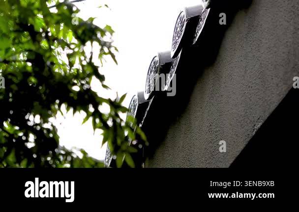 Close-up of raindrops sliding down the roof tiles of an ancient ...