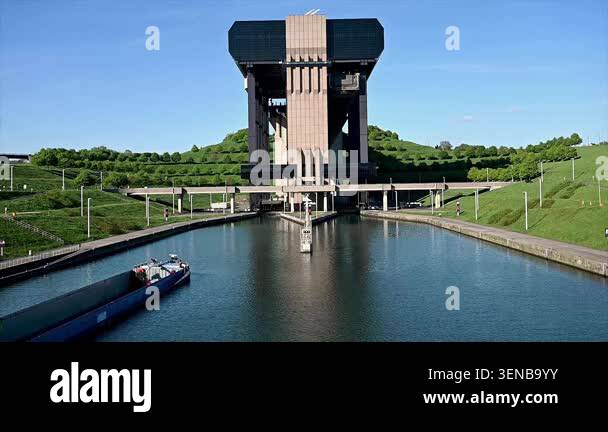 Static view of cargo barge slowly approaching canal boat lift area with ...