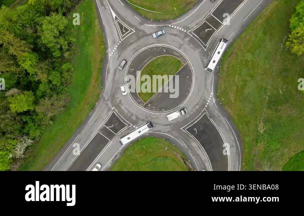 Aerial drone slow zoom-in on roundabout with steady traffic flow of ...
