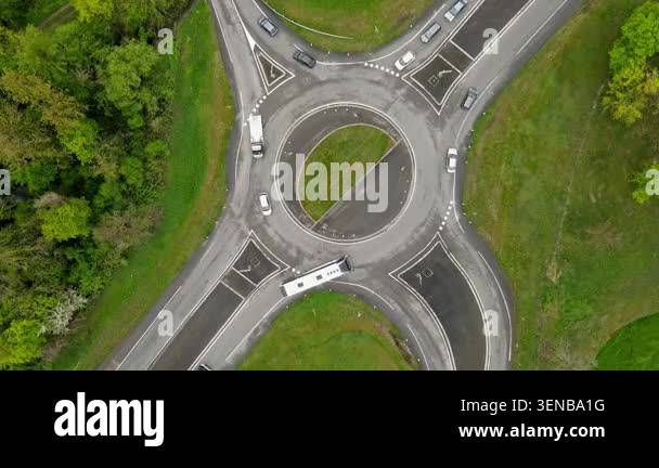 Aerial drone slow zoom-in on busy roundabout with multiple trucks and ...