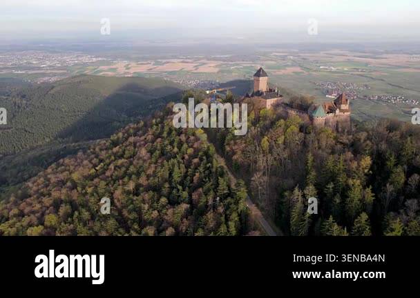 Cinematic aerial drone view of medieval castle amid rolling green hills ...