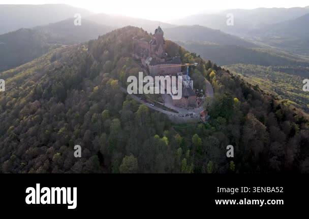 Aerial view of medieval castle on green mountain slope catching ...