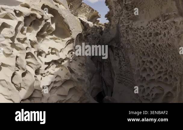 Majestic aerial view flying forward through a narrow desert gorge with ...