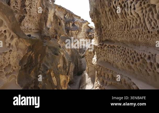 Majestic aerial view flying backward through a narrow canyon of ancient ...
