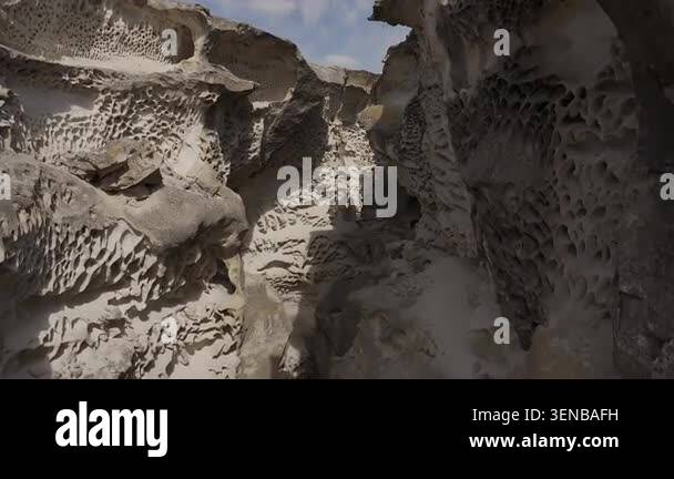 Slow aerial flight descending into a narrow sandstone canyon with ...