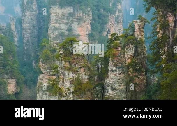 Sandstone pillar with pine trees rising among rock formations in ...