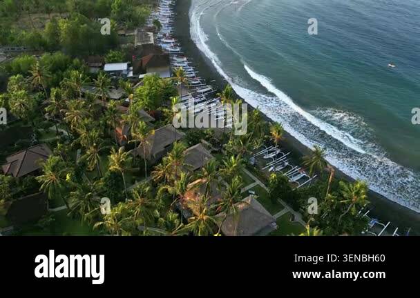 Aerial view of a black tropical beach in Bali with a wavy ocean ...