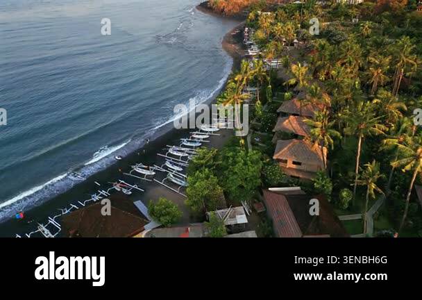 Aerial view of a black tropical beach in Bali with a wavy ocean ...