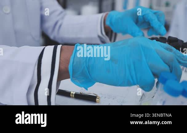scientist in laboratory holding glass tube with chemical liquid in lab ...