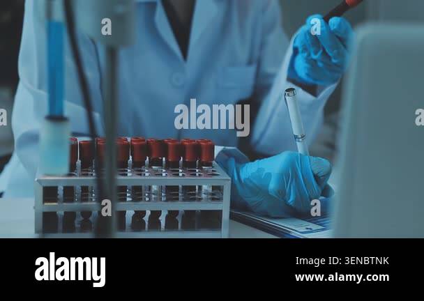 scientist in laboratory holding glass tubes and blood sample Stock ...
