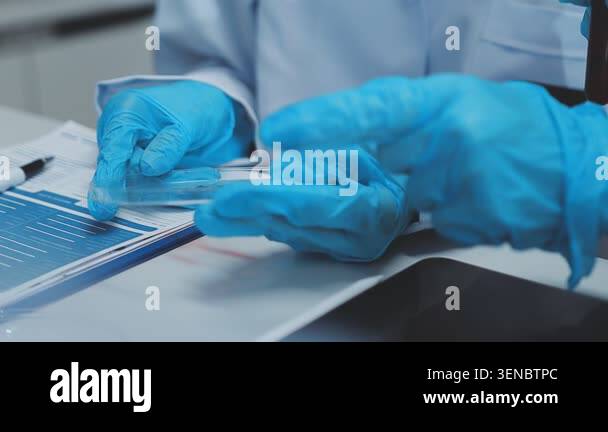 scientist in protective suit holding test tube with liquid in ...