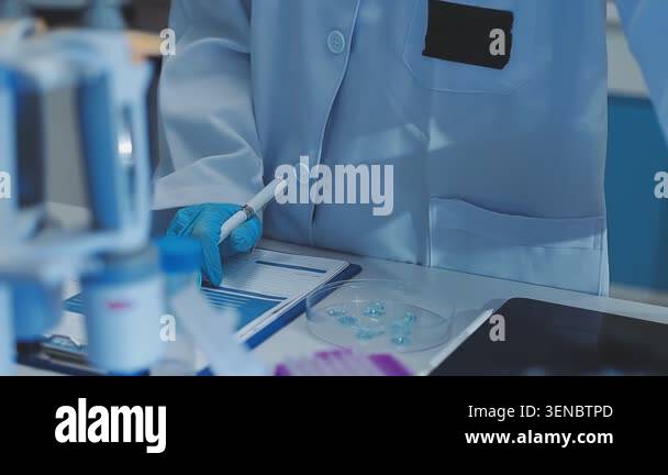 close of scientist in protective glasses working with microscope in ...