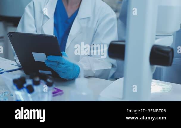 young woman doctor in white lab coat holding tablet with blood sample ...