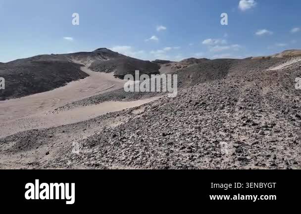 Panoramic camera movement across a vast, arid, and rocky desert ...