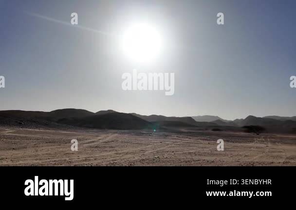 Barren, arid and rocky desert landscape under a clear blue sky with a ...