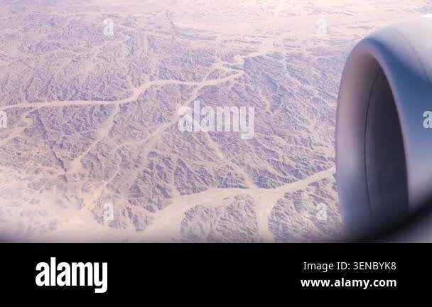 Aerial view from an airplane window showing the vast, arid desert ...