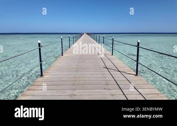 First-person perspective walking on a long wooden pier over the ...