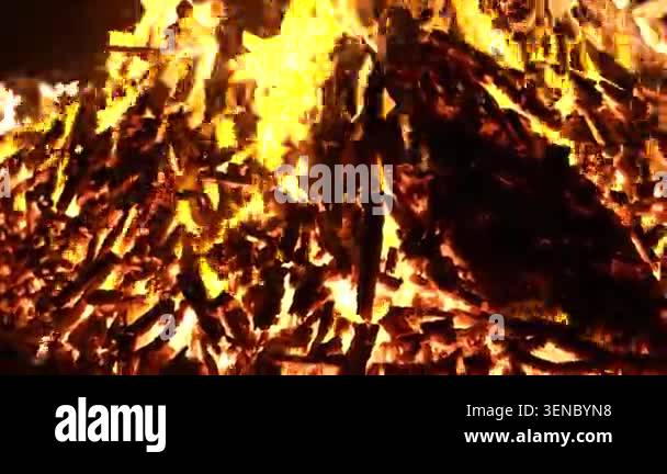 Close up view of a massive bonfire burning intensely at night, with ...
