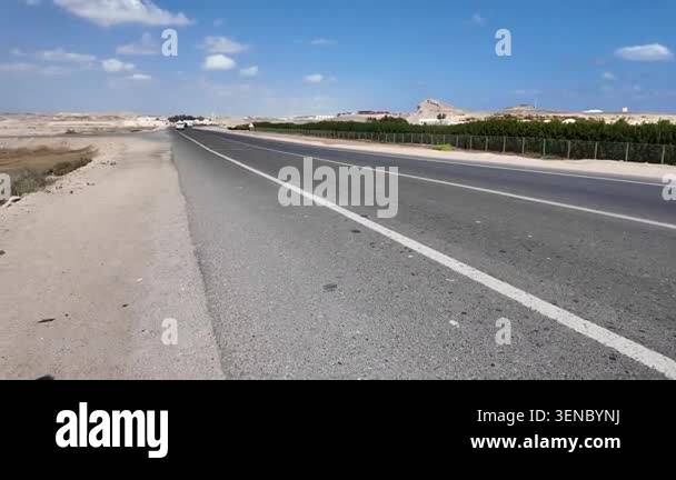 White tanker truck transporting water and driving down a paved road in ...