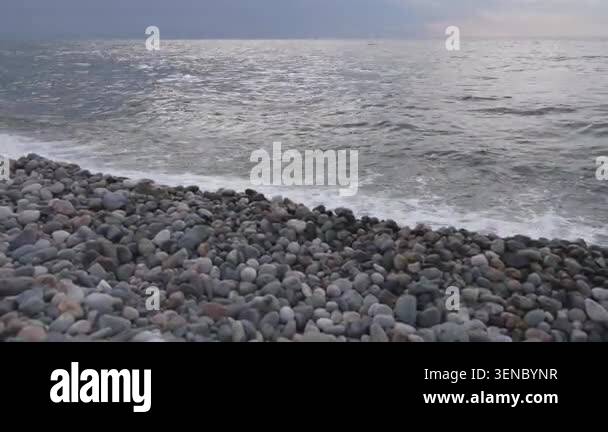 Overcast day on the black sea coast with gentle waves rolling over a ...