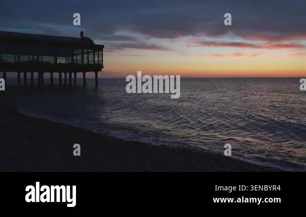 Beautiful sunset over the black sea with a pier silhouette on the left ...