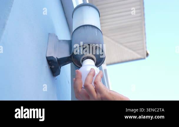 Close up shot of a person hand replacing or installing an energy-saving ...