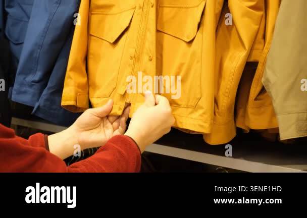 A man chooses a colorful jacket in clothing store close-up Stock Video ...