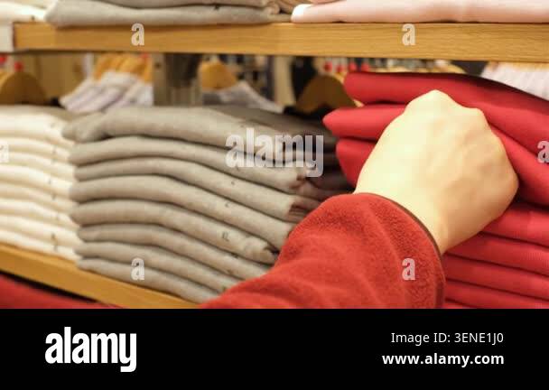 A hand chooses clothes on shelves in the store close-up Stock Video ...