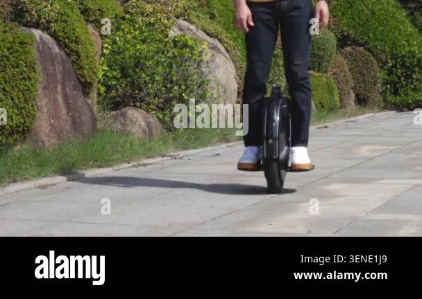 A man rides electric unicycle in city park, front view Stock Video ...
