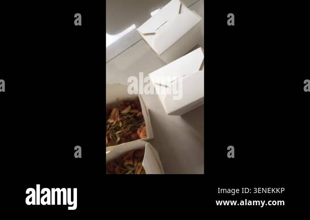 A high-angle shot of several plain white cardboard food boxes stacked ...