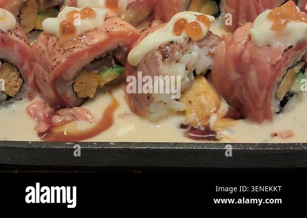 A horizontal close up video tracking along a row of bacon wrapped rolls ...