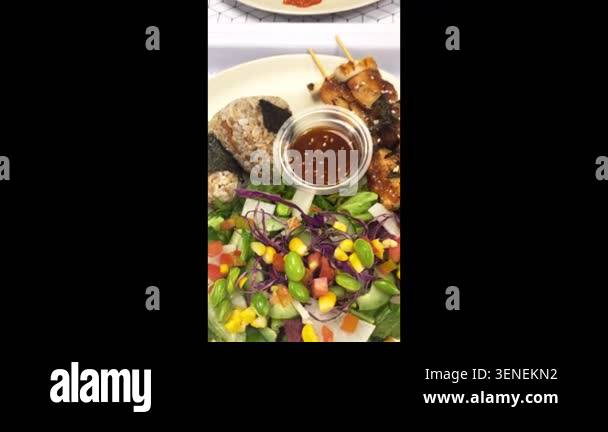 A vertical shot of a plate featuring a healthy burger topped with ...