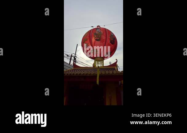 A vertical shot of a large red decorative Chinese lantern hanging at a ...