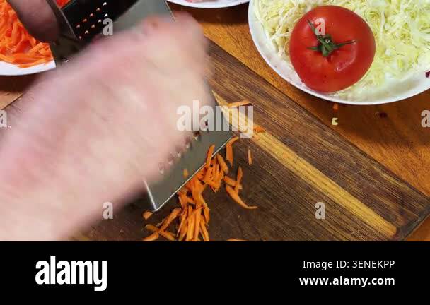 Grating carrot with hand grater on a wooden cutting board Stock Video ...