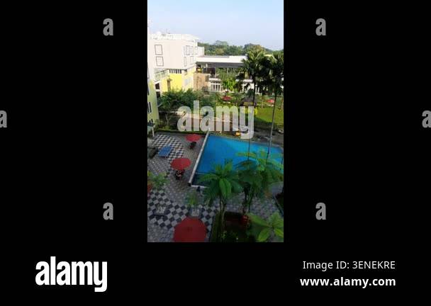 A vertical high-angle shot overlooking a large blue swimming pool ...