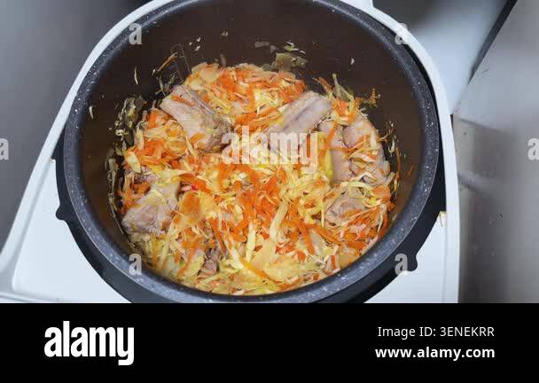 Pork ribs with vegetables during frying in multi-cooker pot Stock Video ...