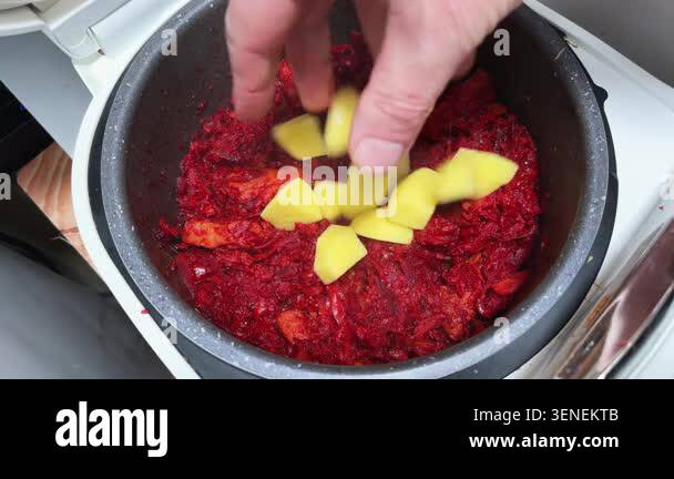 Adding potato to meat, vegetables in multicooker for borscht cooking ...
