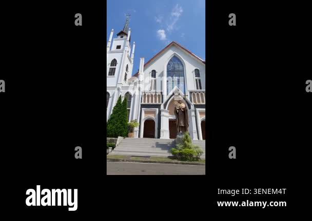 A wide vertical shot of a modern church building with white walls and a ...