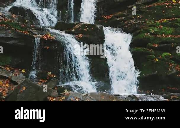Slow-motion 4K pan video waterfall stream falling down rocks and stones ...