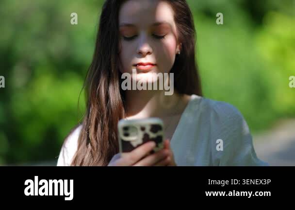 Beautiful young woman with a piercing texting on her smartphone ...