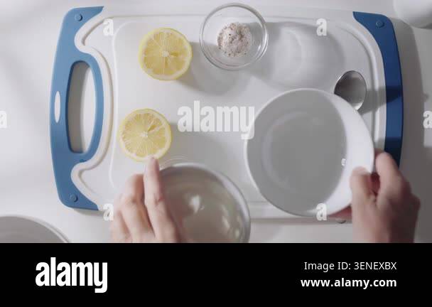 Hands stir Greek yogurt in a bowl while preparing a creamy homemade ...