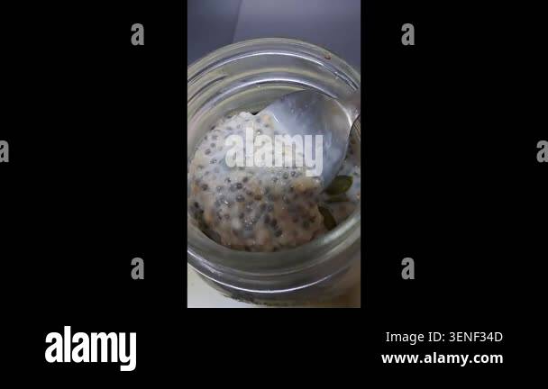 A top-down view of chia seed pudding with pumpkin seeds in a glass jar ...