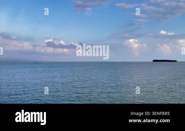 Serene Sea View with Blue Sky, Fresh Clouds, and Distant Fishing Boats ...